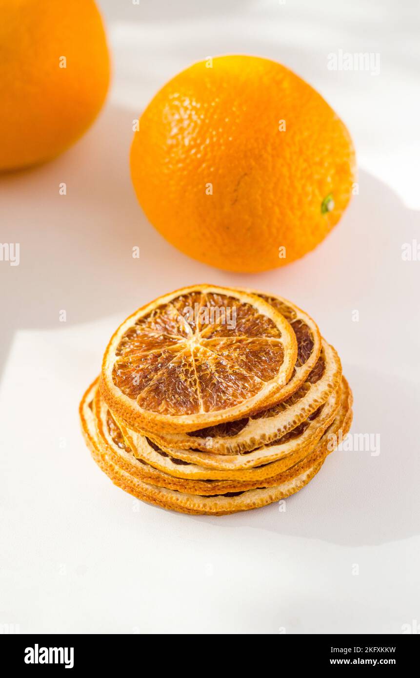 Ripe juicy oranges on grey background and dried orange chips around ...