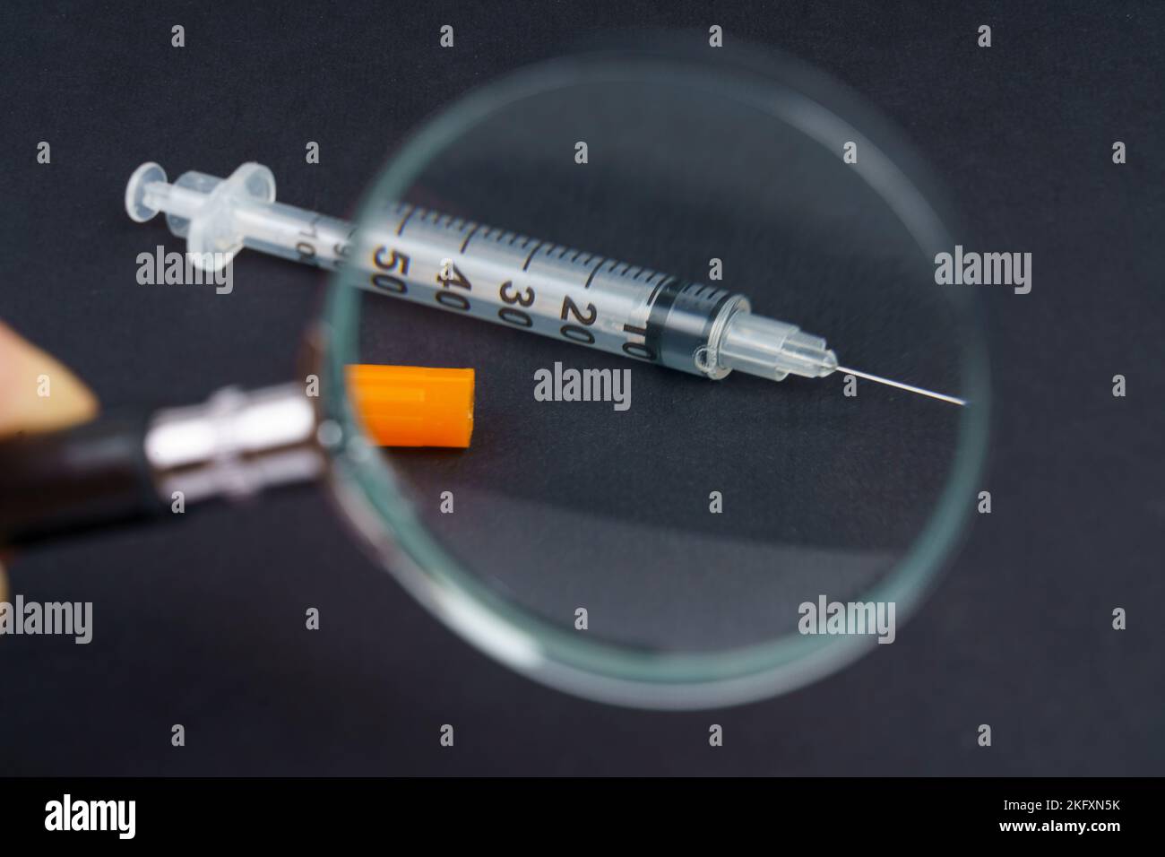Medicine and health concept. A syringe lies on a black background. A ...