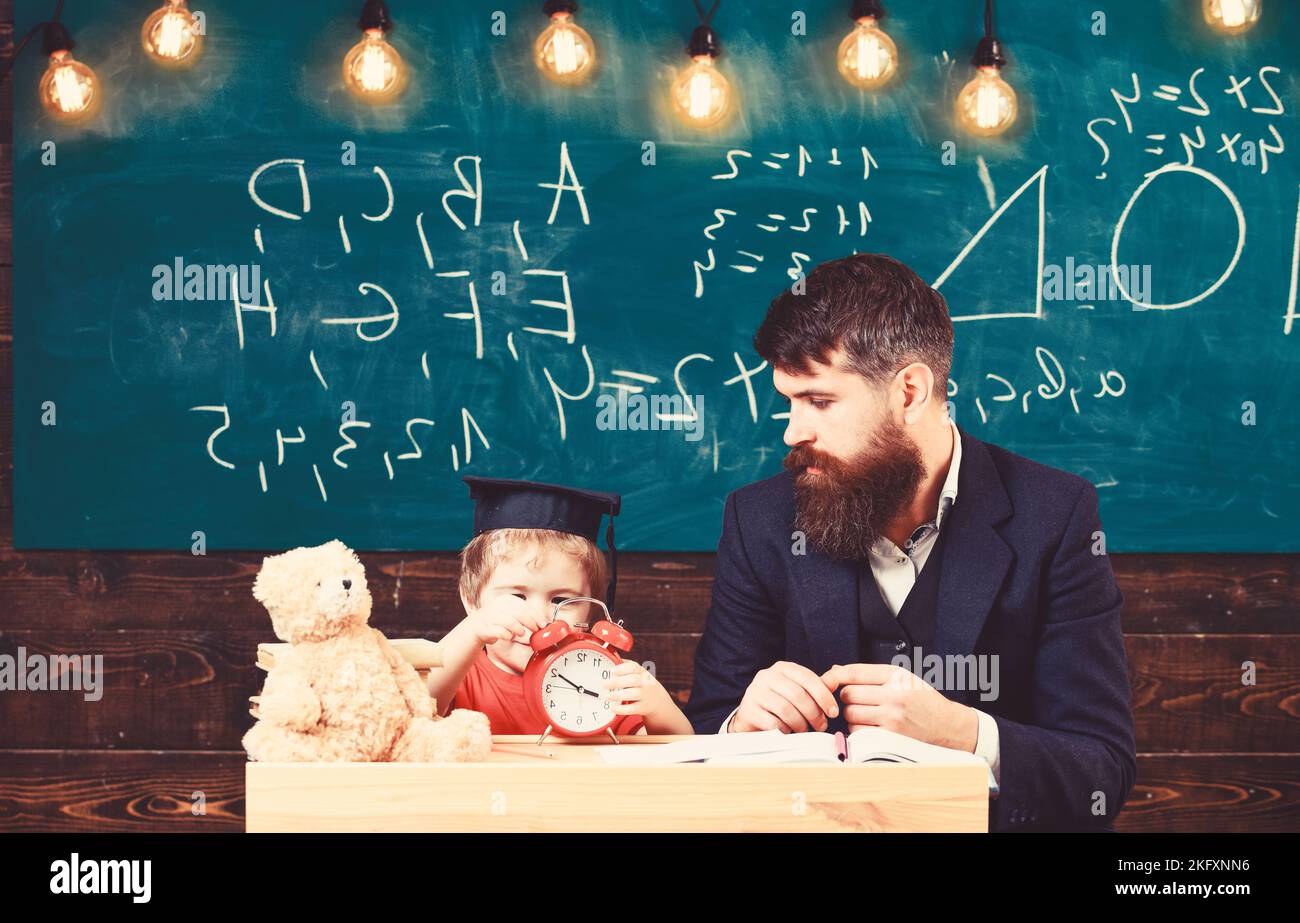Young male teacher guides his child student to learning while sitting ...