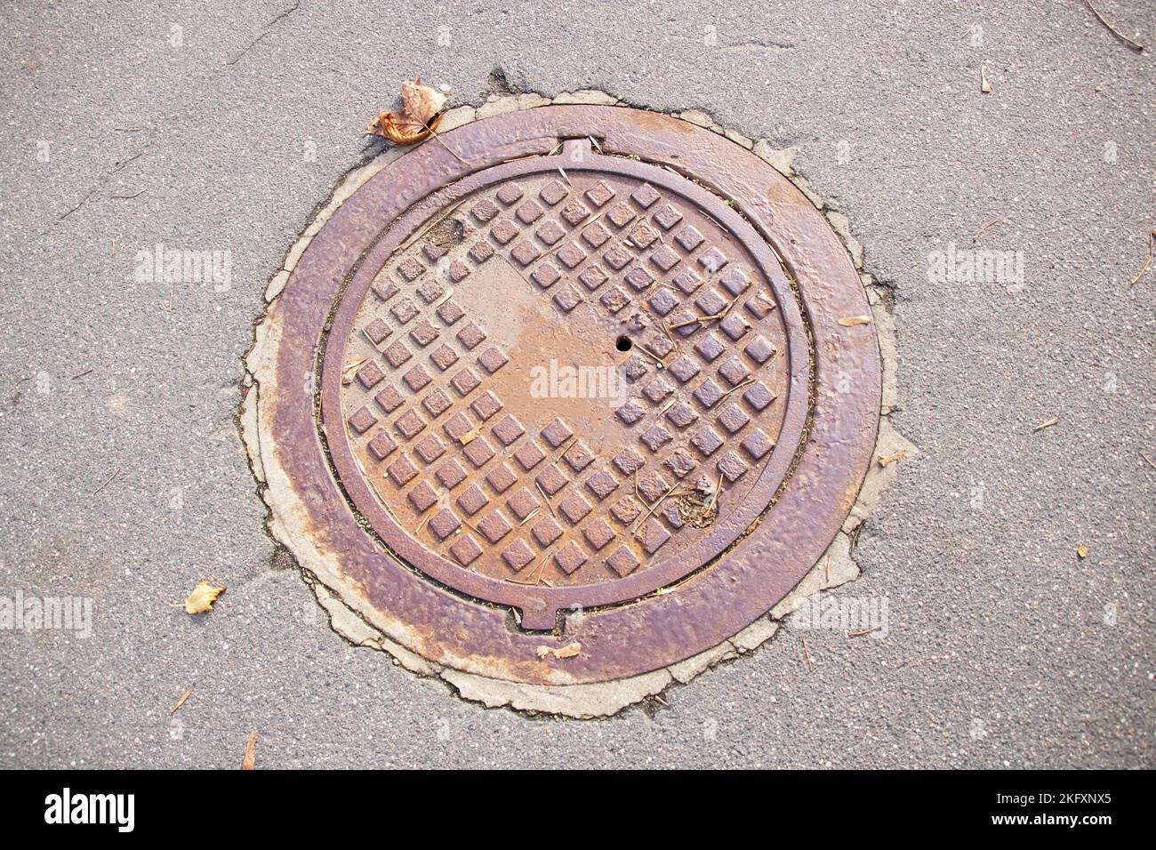 Sewer manhole with lid on the sidewalk close up Stock Photo - Alamy