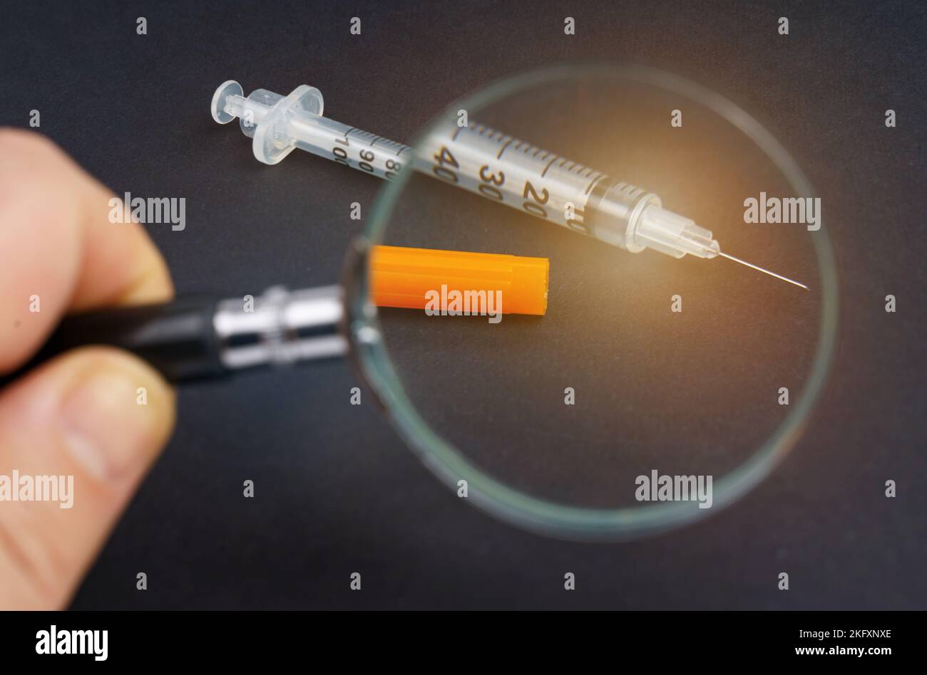 Medicine and health concept. A syringe lies on a black background. A ...