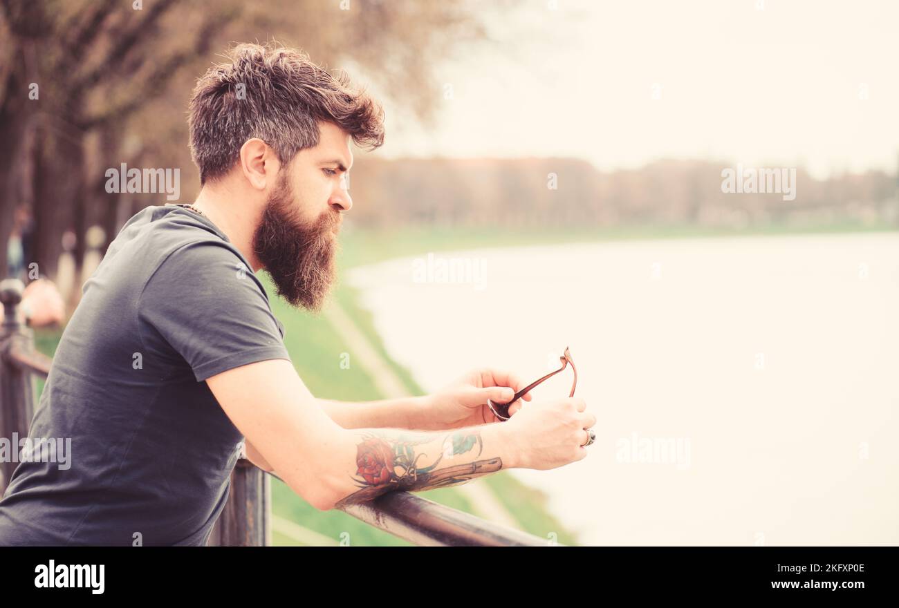Man with beard and mustache with sunglasses, riverside on background ...