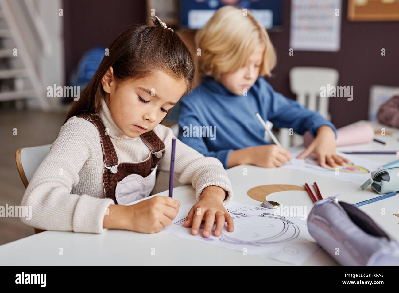 Selective focus on diligent pretty learner of primary school drawing on ...
