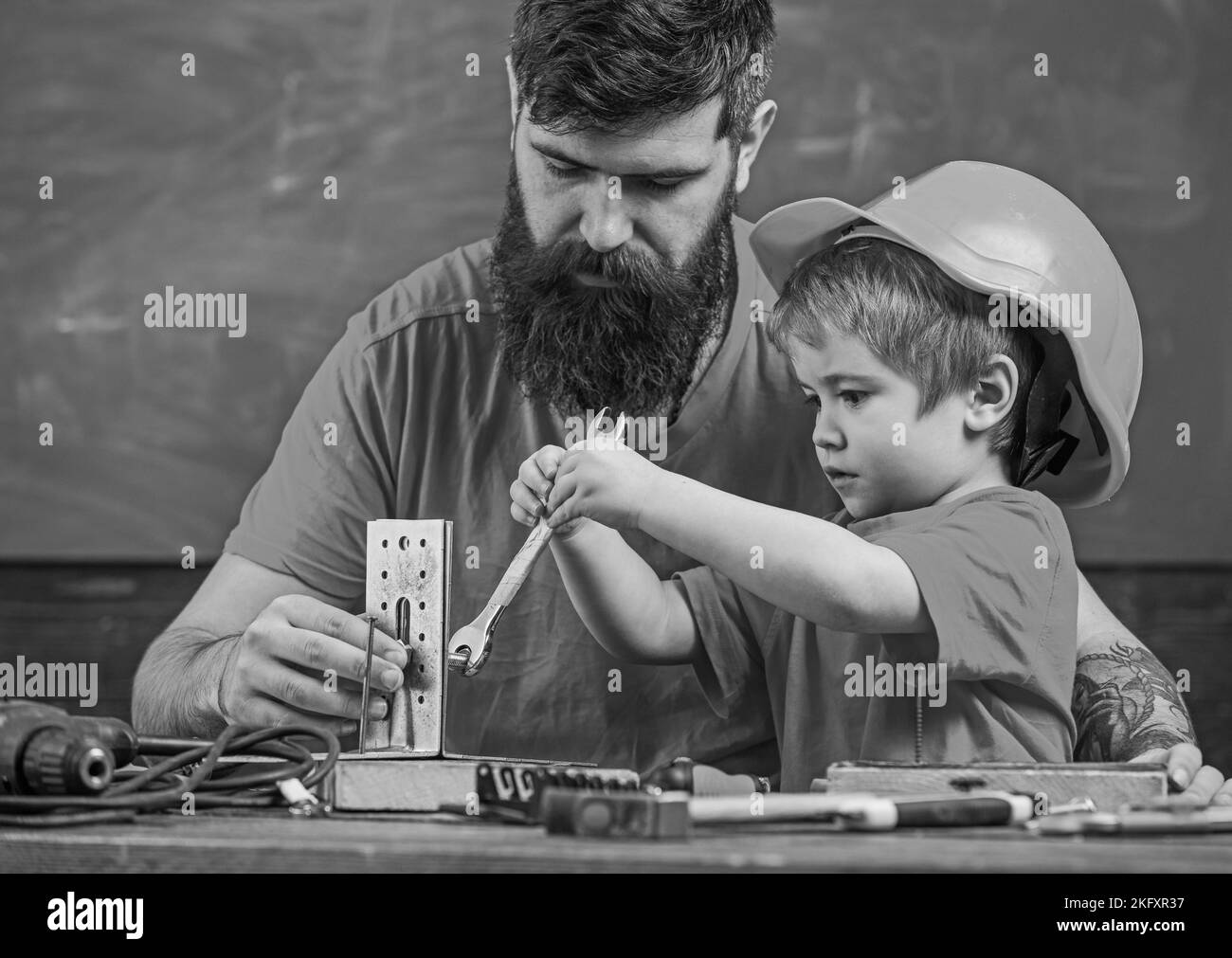 Boy, child busy in protective helmet makes by hand, repairing, does ...
