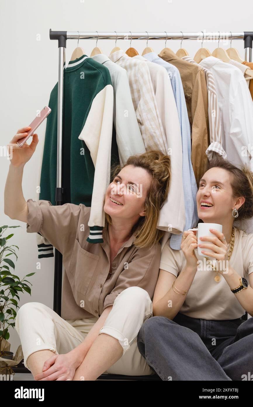 Wardrobe organization concept - two female friends making selfie near ...