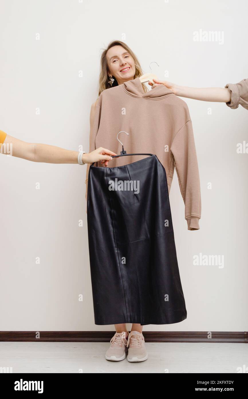 Two hands holding clothes on hangers for woman. Fashion shopping ...