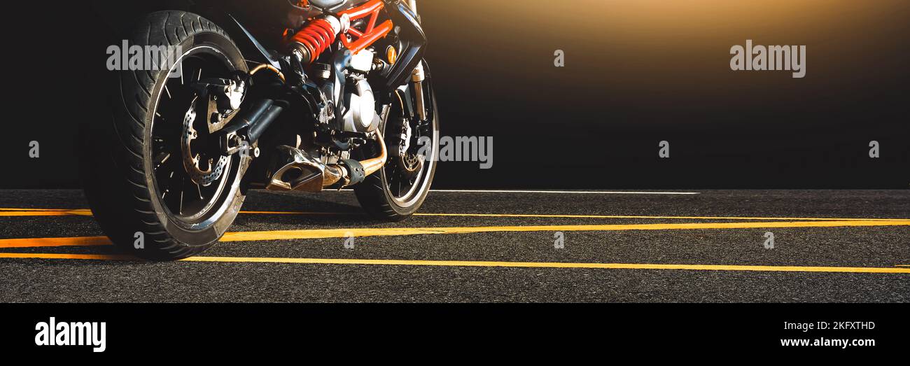 Motorcycle parked alone on a asphalt road in the night time,horizontal ...