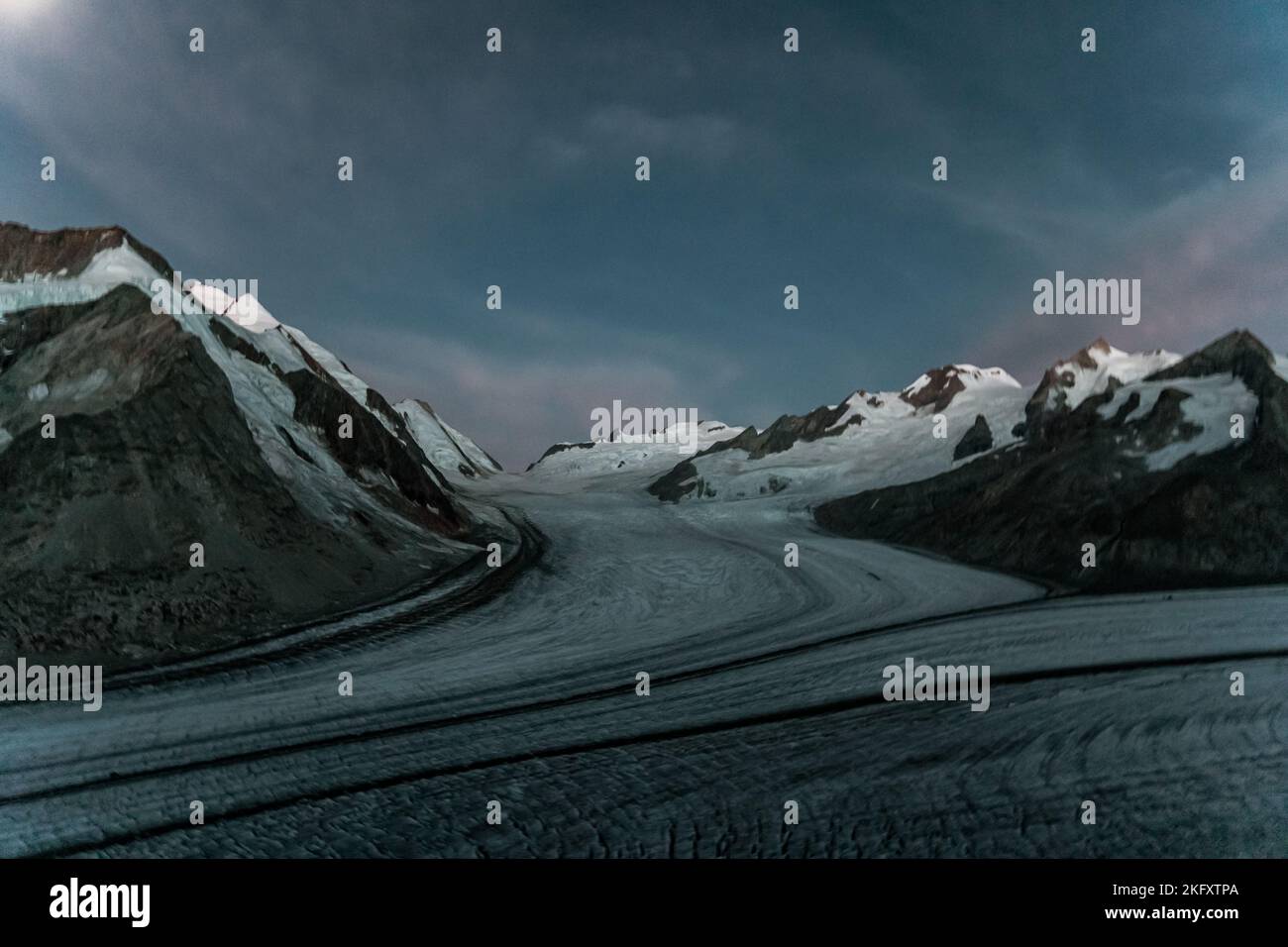 A beautiful shot of the snowy rocky mountains under an evening sky in ...