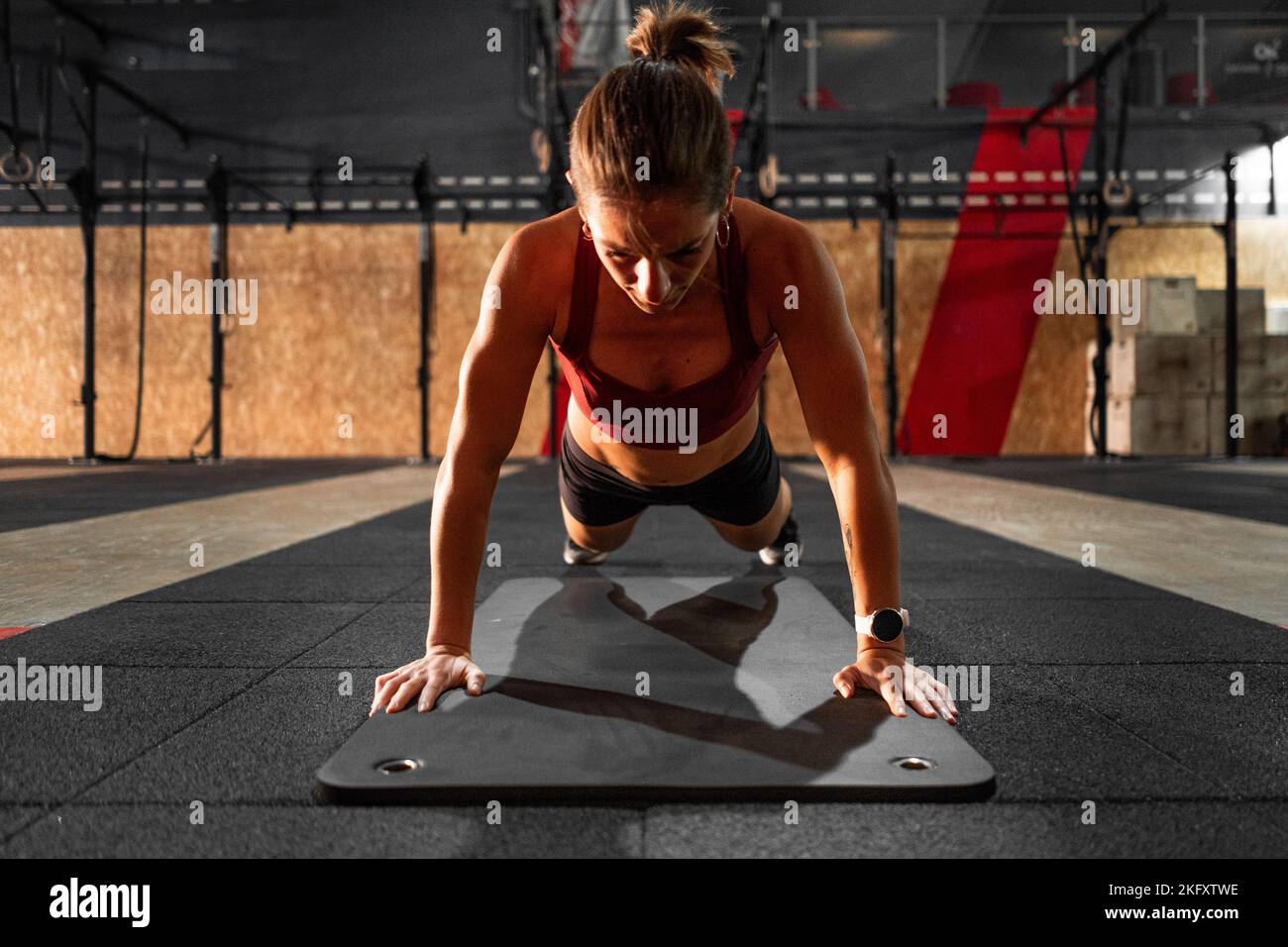 brunette caucasian girl doing sports lying on a soft mat in a gym Stock ...