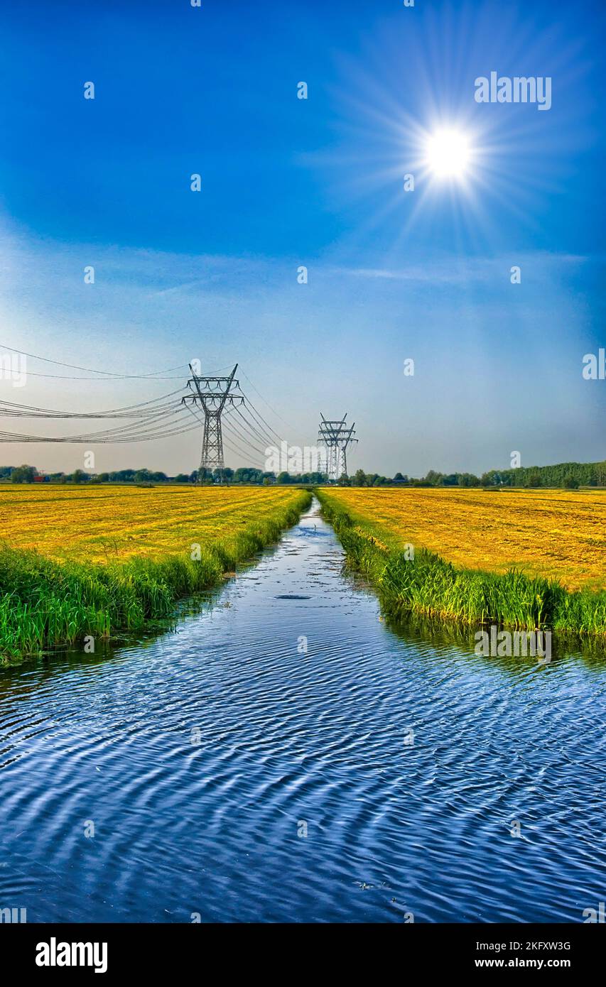 Dutch landscape with a canal and grass fields with mirror reflection in ...