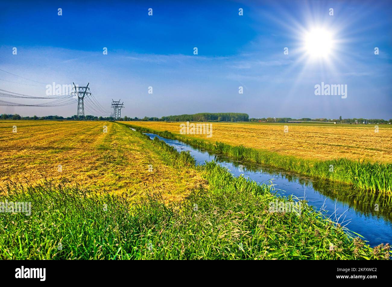 Dutch landscape with a canal and grass fields with mirror reflection in ...