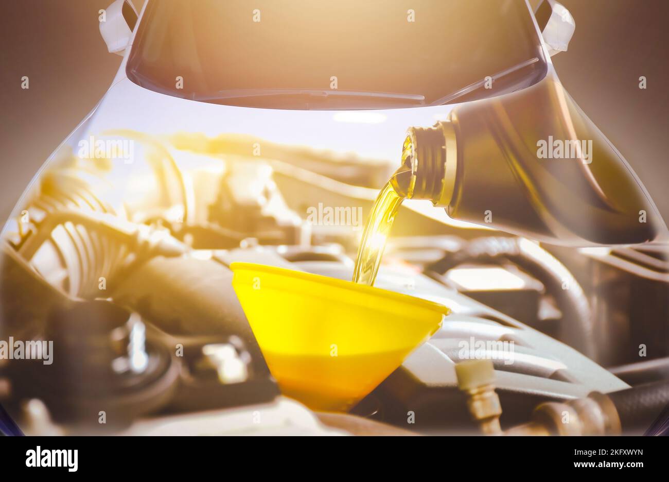 The Engine oil pouring into the car engine with a sunlight and ...