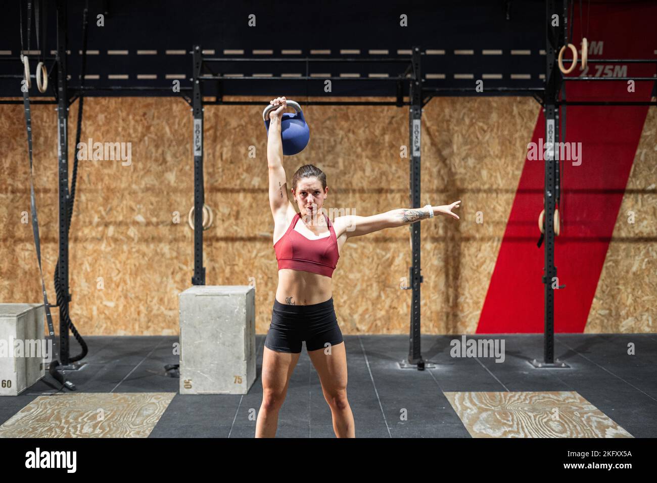 Caucasian girl standing with tattooed arms with her left arm ...