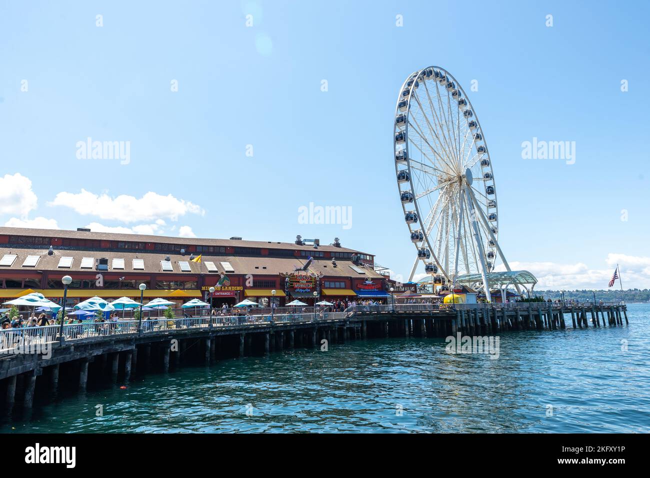 The Seattle pier at water with ferris wheel Stock Photo - Alamy