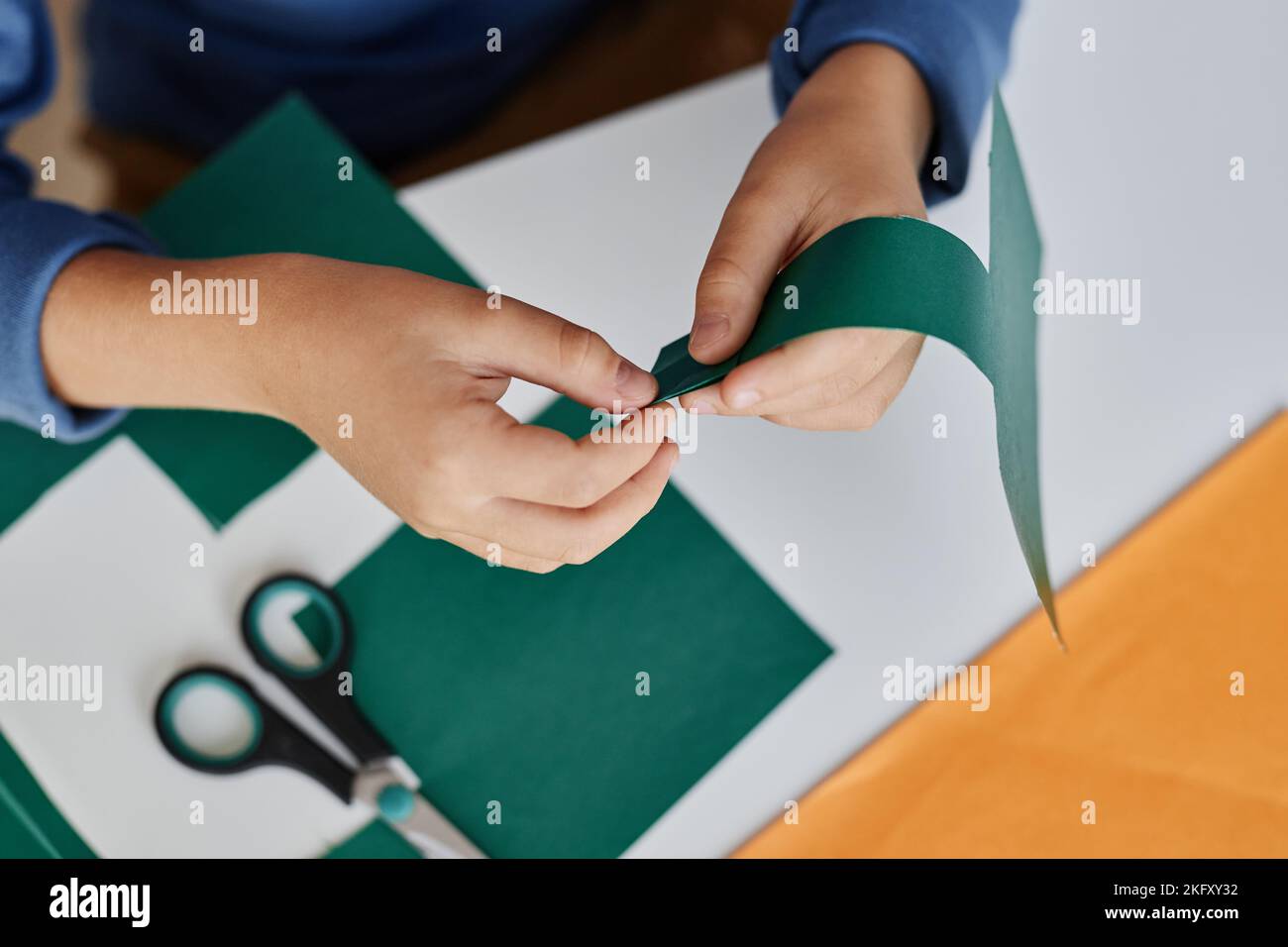 Selective focus on hands of little boy with vintage green paper ...