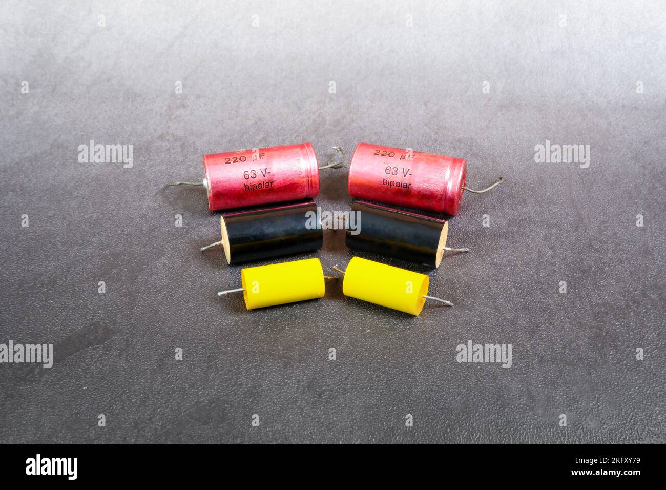 Bipolar capacitors of various sizes are arranged in a row on the cement ...