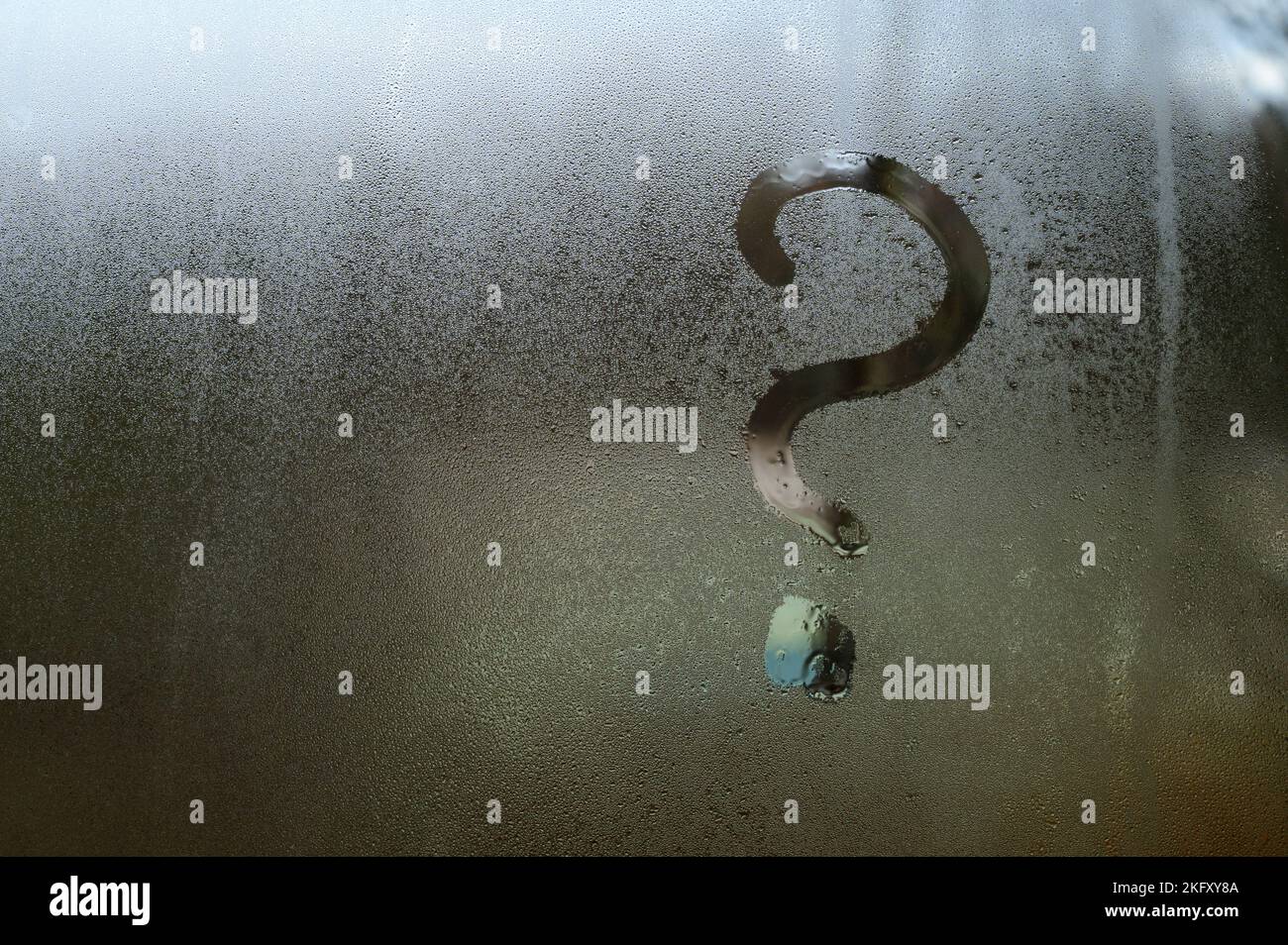 A question mark is drawn on glass with condensation, the effect of ...