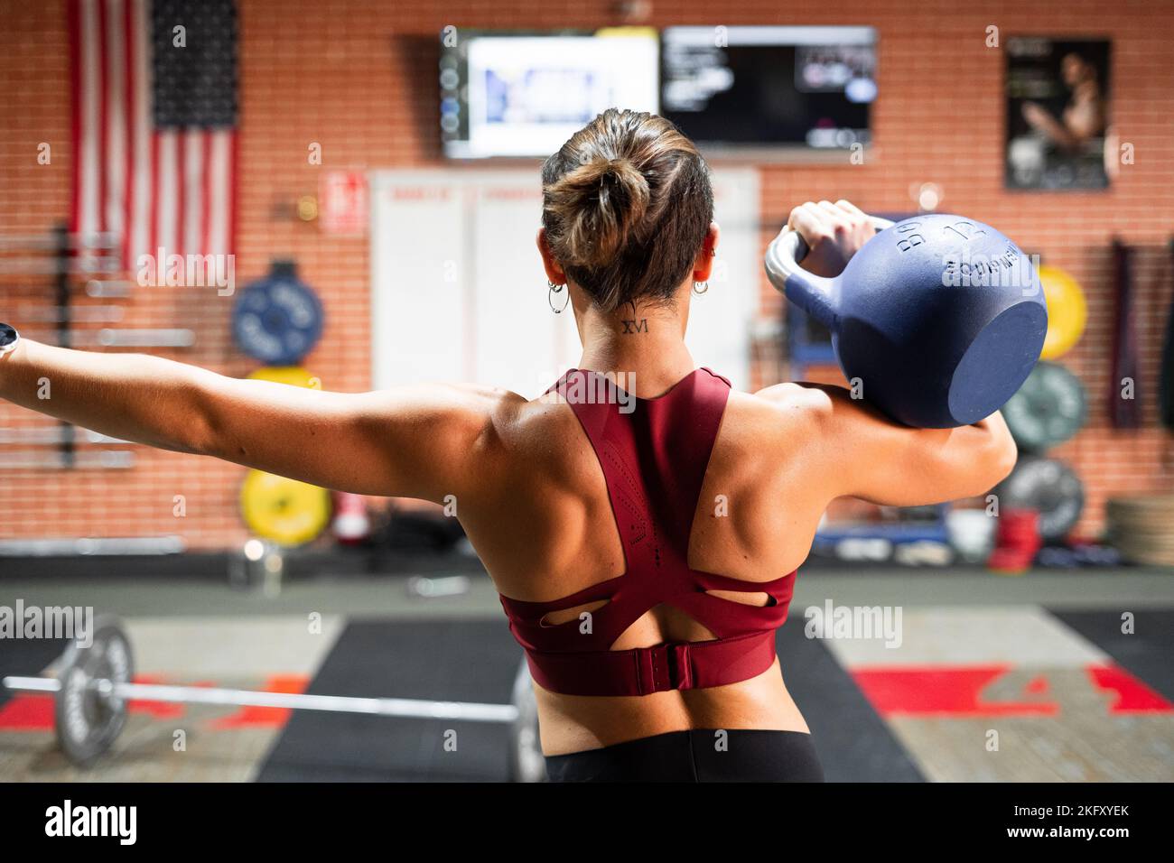caucasian girl standing on her back in the gym forcefully lifting a ...