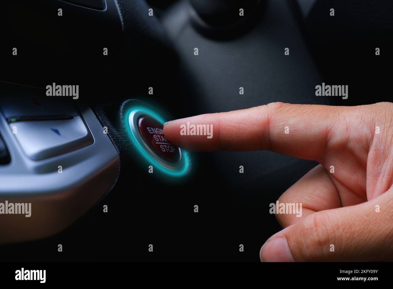 The driver palm as it presses the electric car engine start stop button ...