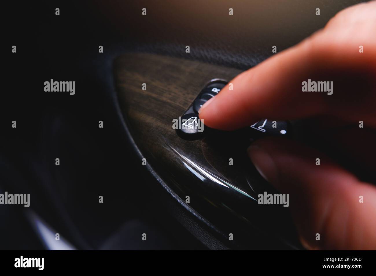 The driver presses the power folding mirror button switch with his hand ...