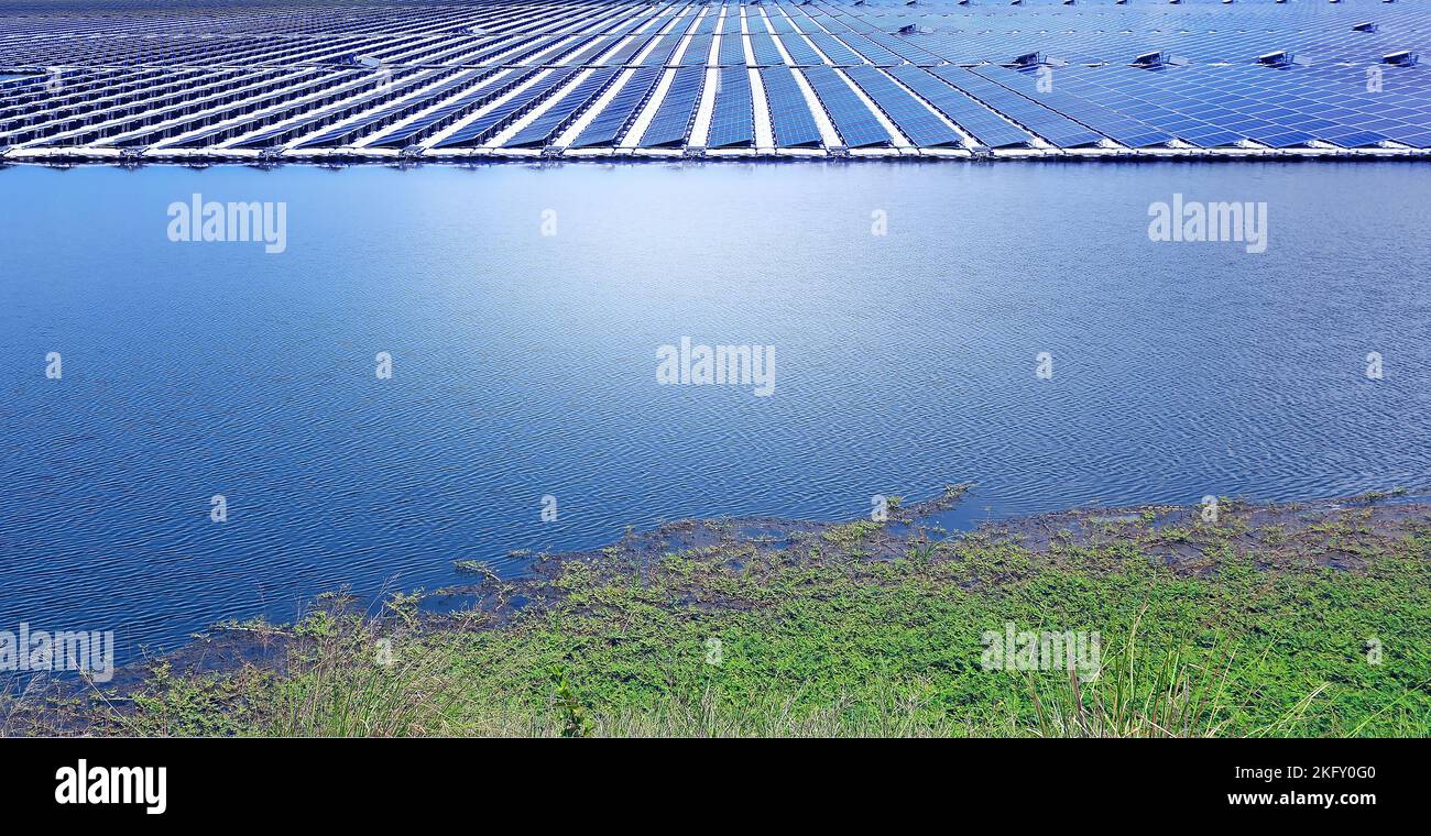 Solar panels float on the surface of the lake with the sky and sunlight ...