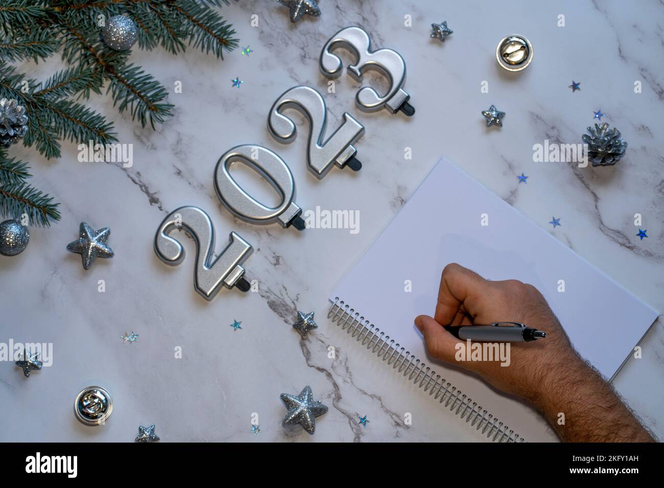 a man's hand writing down in a notebook the aims and objectives of the ...