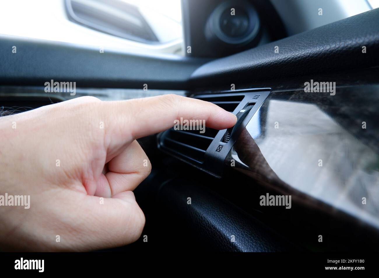 The driver hand adjust the wind speed of the car air vent in a car ...