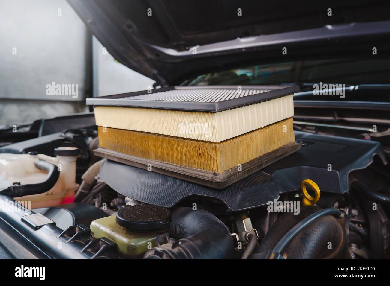 Comparing new and used car air filters placed on the engine Stock Photo ...