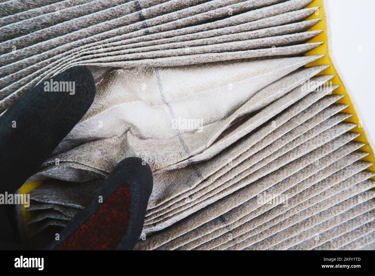 Auto mechanic hand open the old air filter that is clogged in the car ...