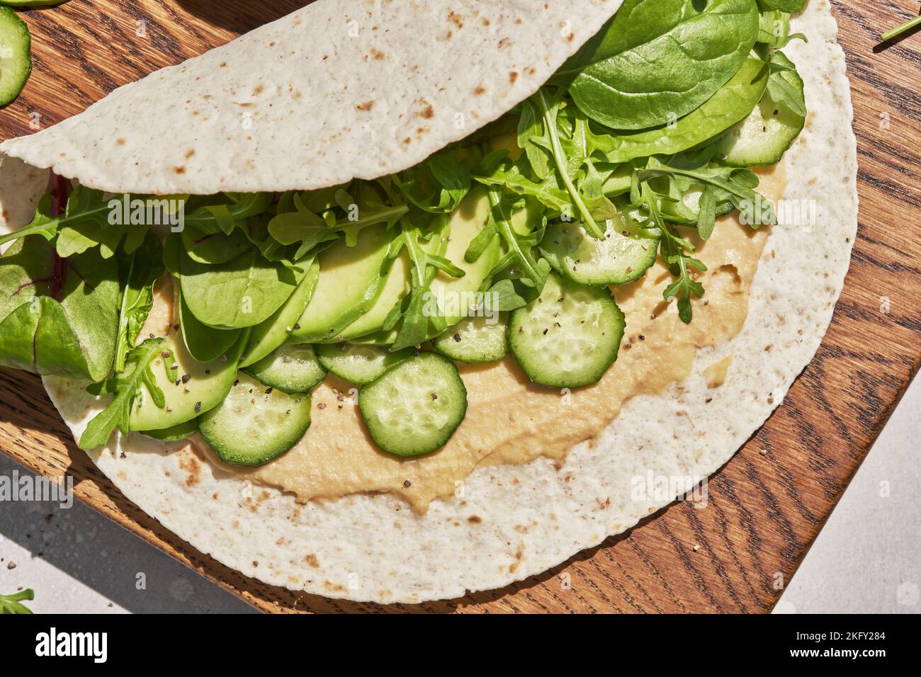Vegetarian tortilla with hummus and green vegetables Stock Photo - Alamy