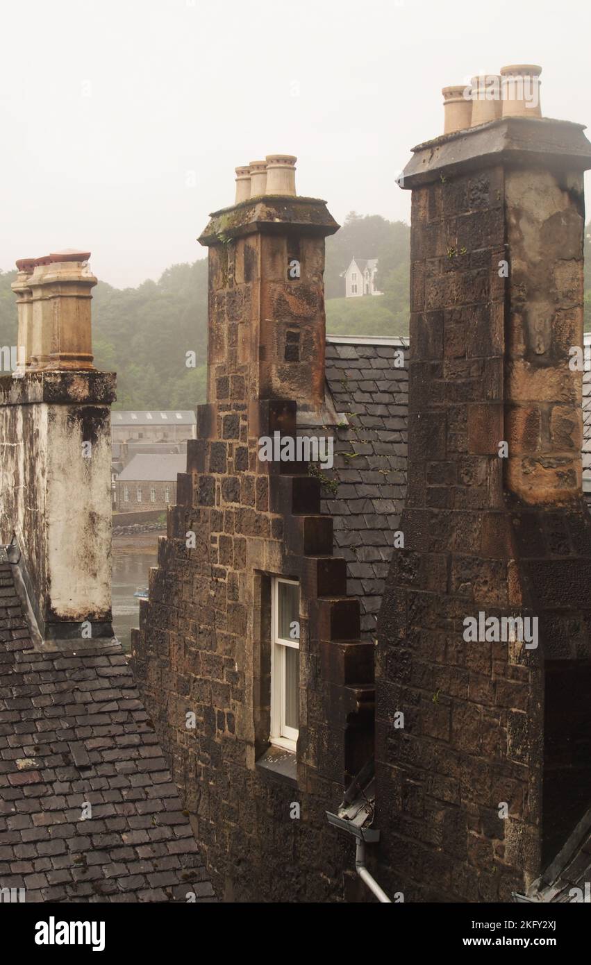 Old chimney stacks on top of old houses above the harbour at Tobermory ...