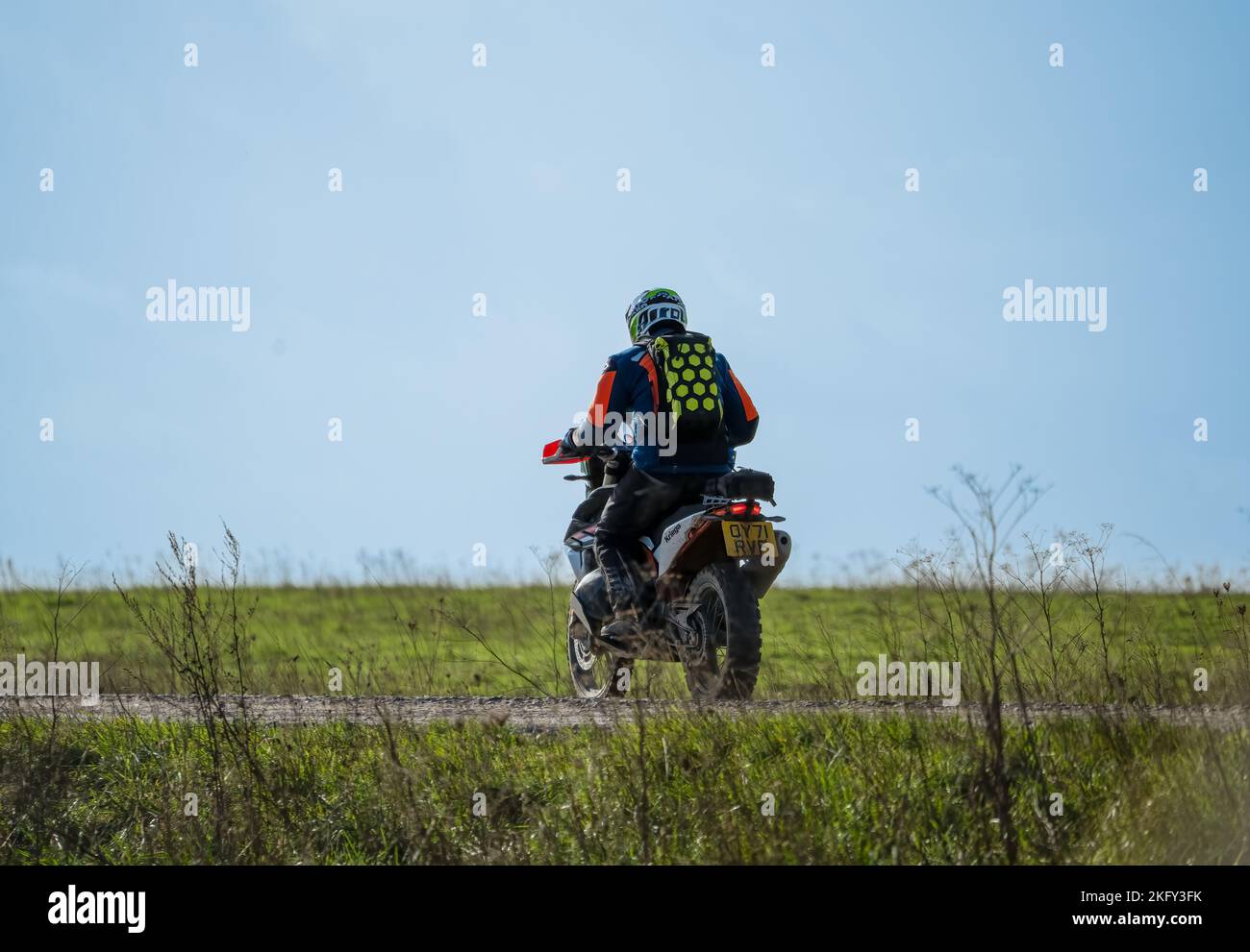 motor cyclist (biker) riding an off-road motorbike along a stone track ...