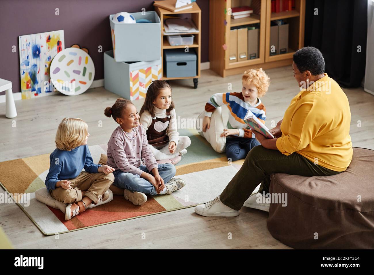 Several adorable intercultural kids gathered on the floor in front of ...