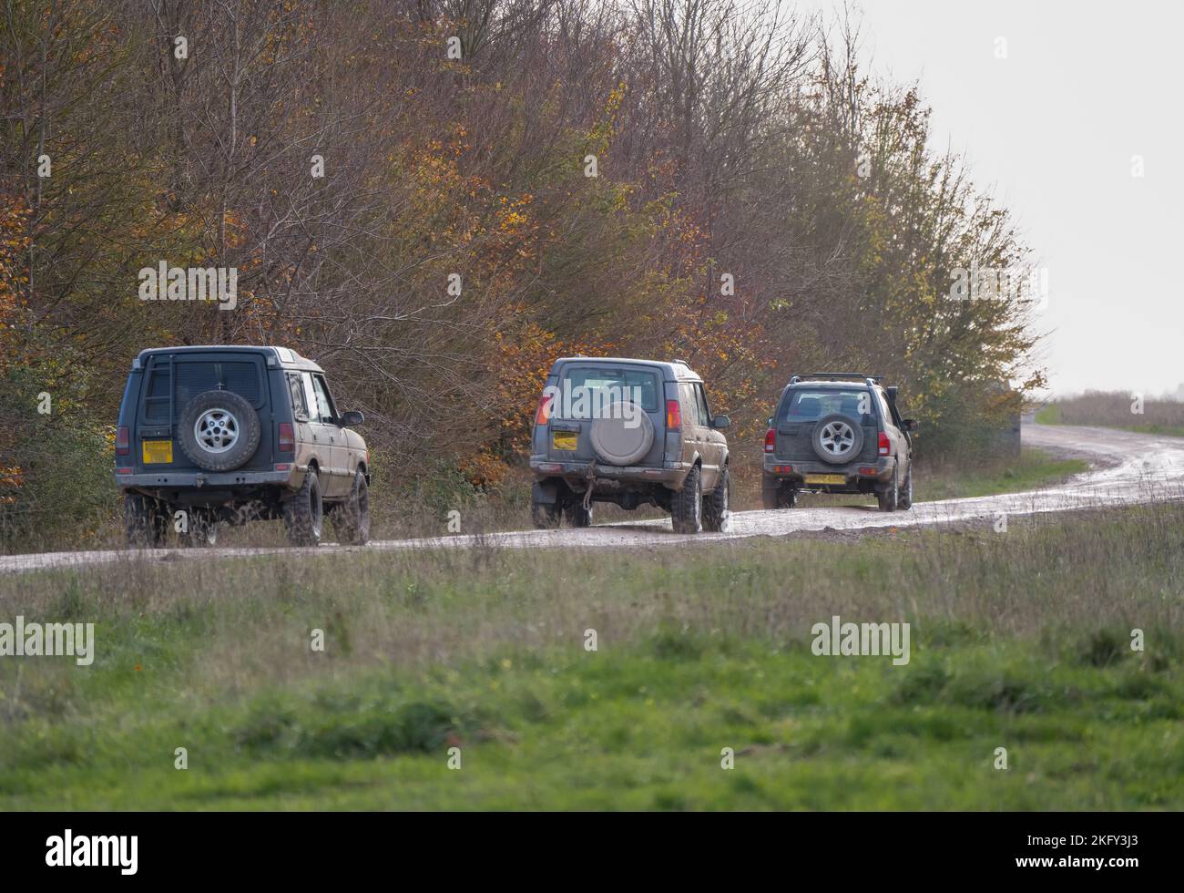 three modified off-road 4x4 vehicles driving along a mud track, Wilts ...