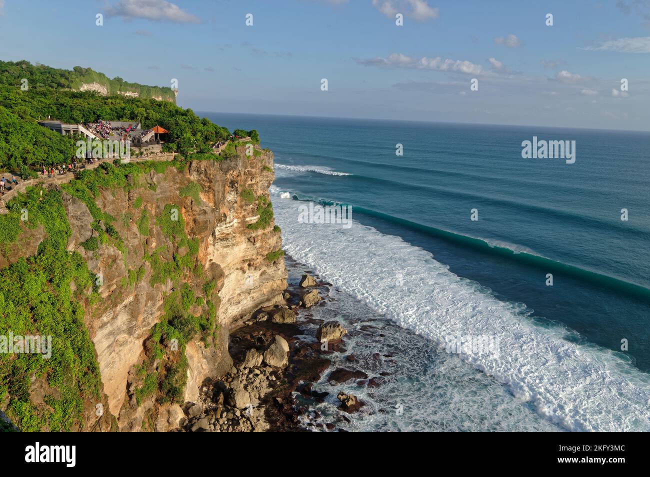 A high-angle shot of a rocky shore with sea waves and the Uluwatu ...