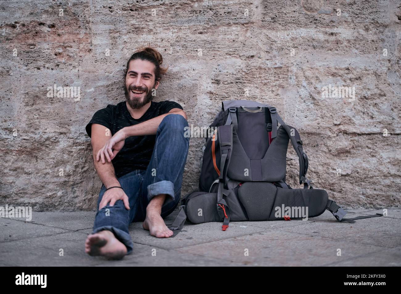 Caucasian Guy With Beard Long Hair Barefoot Sitting On The Floor