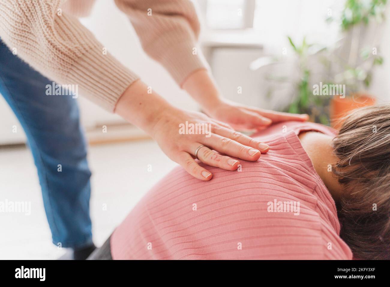 A close-up shot of female hands giving shoulder massage to a pregnant ...