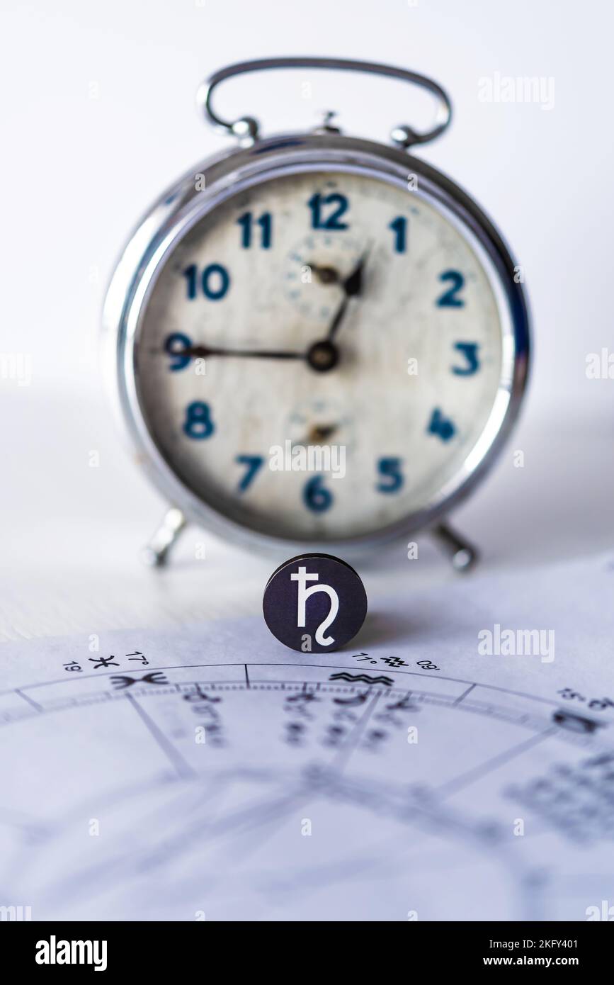 A zodiacal symbol Saturn on a drawing of a natal chart and a defocused ...
