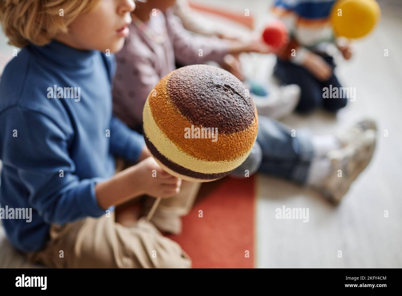 Model of Jupiter held by little learner of nursery school at lesson of ...
