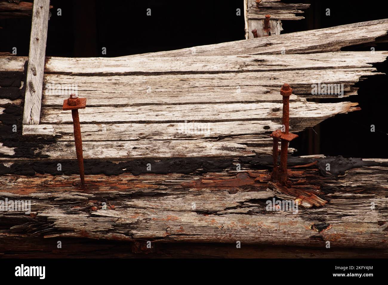 An large, old, wrecked wooden boat, in dry dock, showing the rotting ...