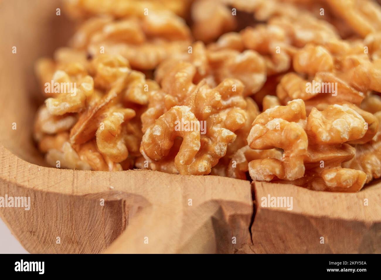 Peeled walnut cores in a cracked rustic wooden bowl. Dry nuts kernels ...