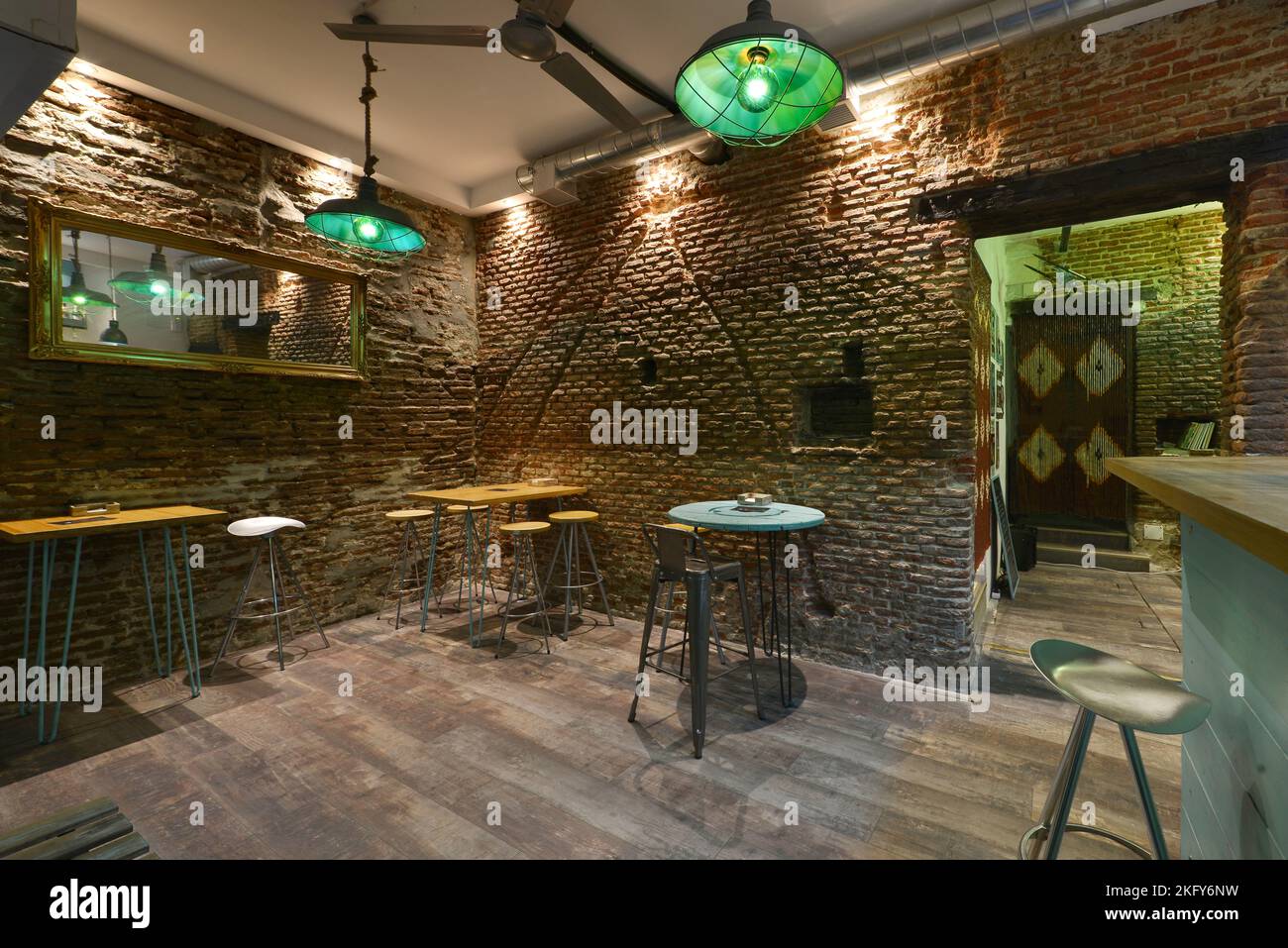 Hall of a bohemian bar with wooden tables, wooden floors and exposed ...