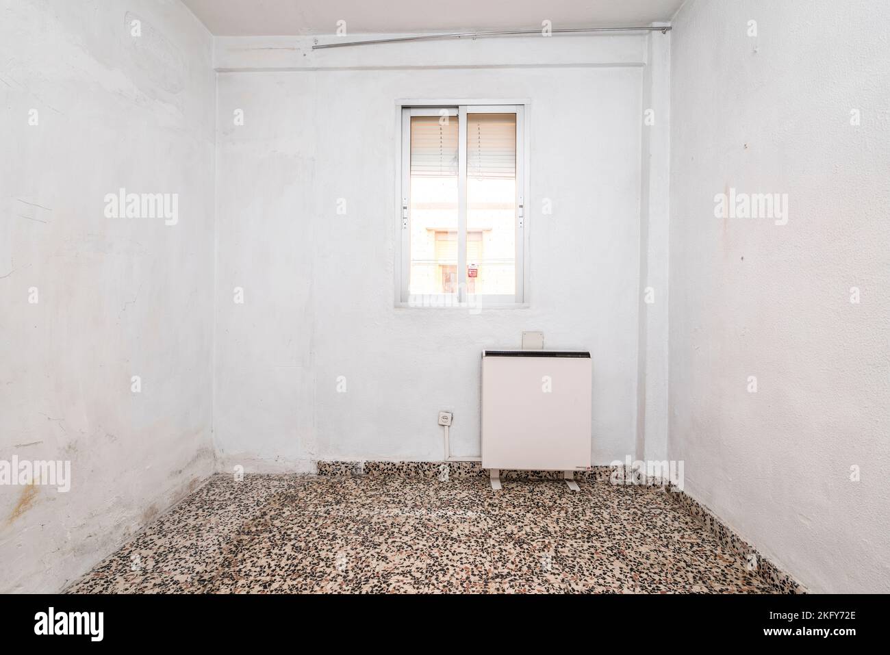 Empty room with poorly painted walls, electric heat accumulator, dirty ...