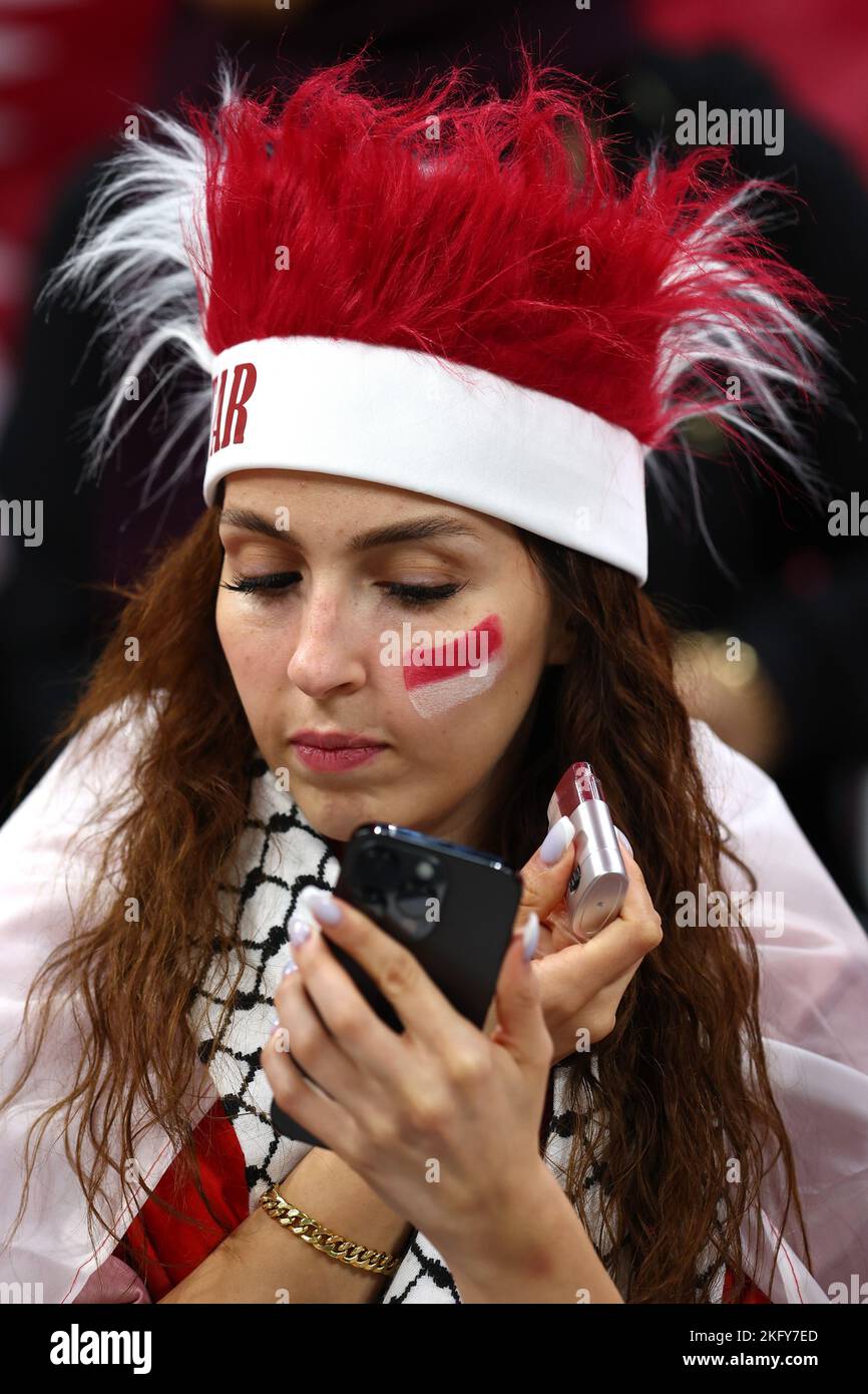 Doha, Qatar. 20th Nov, 2022. A Qatar fan applies make up to her face ...