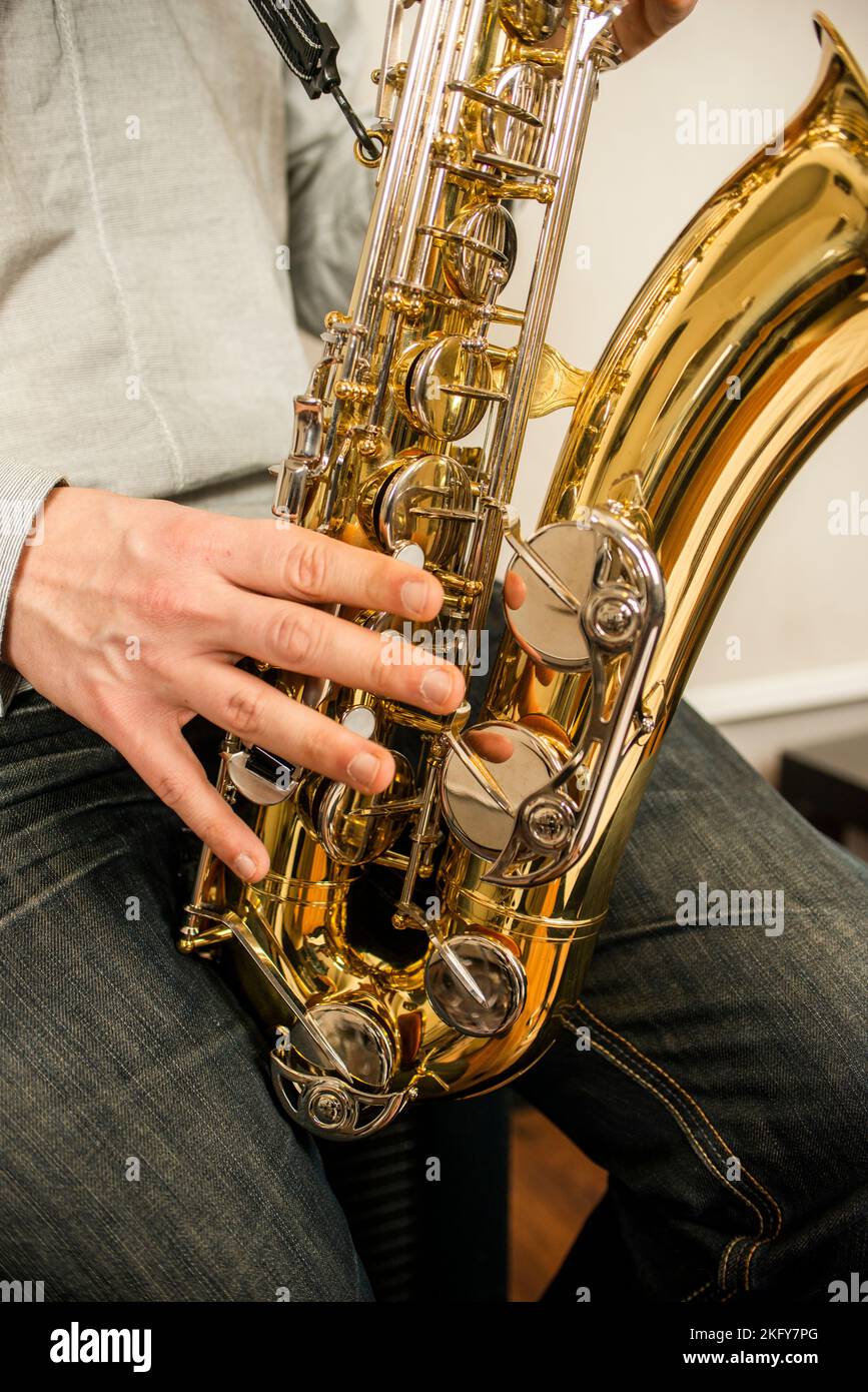 Hands of a musician on a golden and metallic saxophone Stock Photo - Alamy