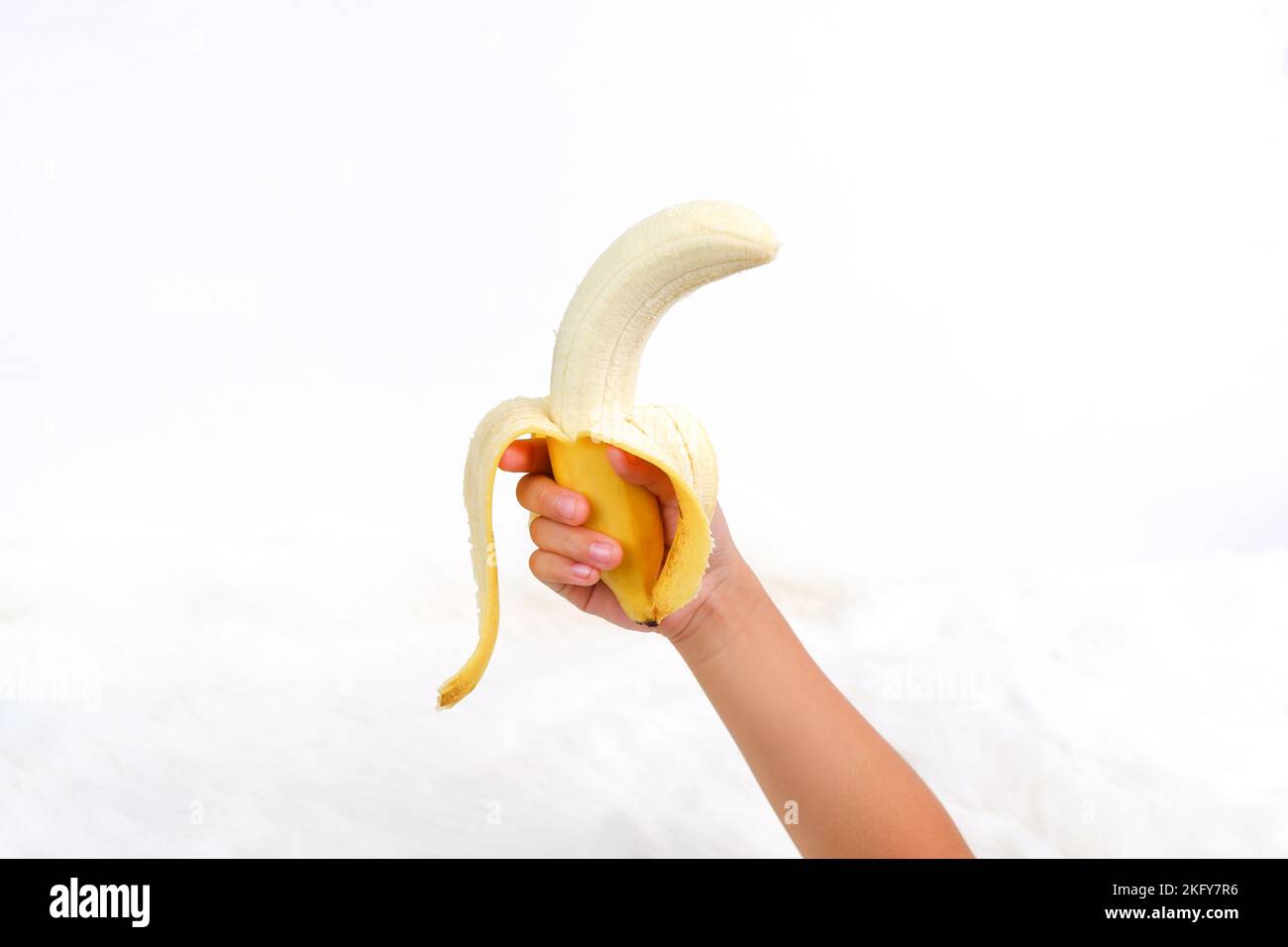 Peeled, ripe cavendish banana in human hand, Object isolated on white ...