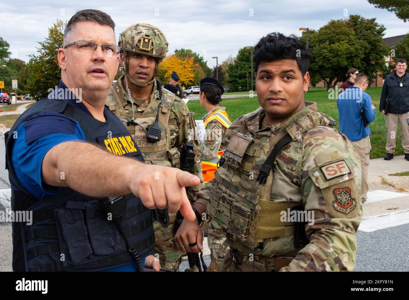 From the left, a member of the Delaware State Police, confers with ...