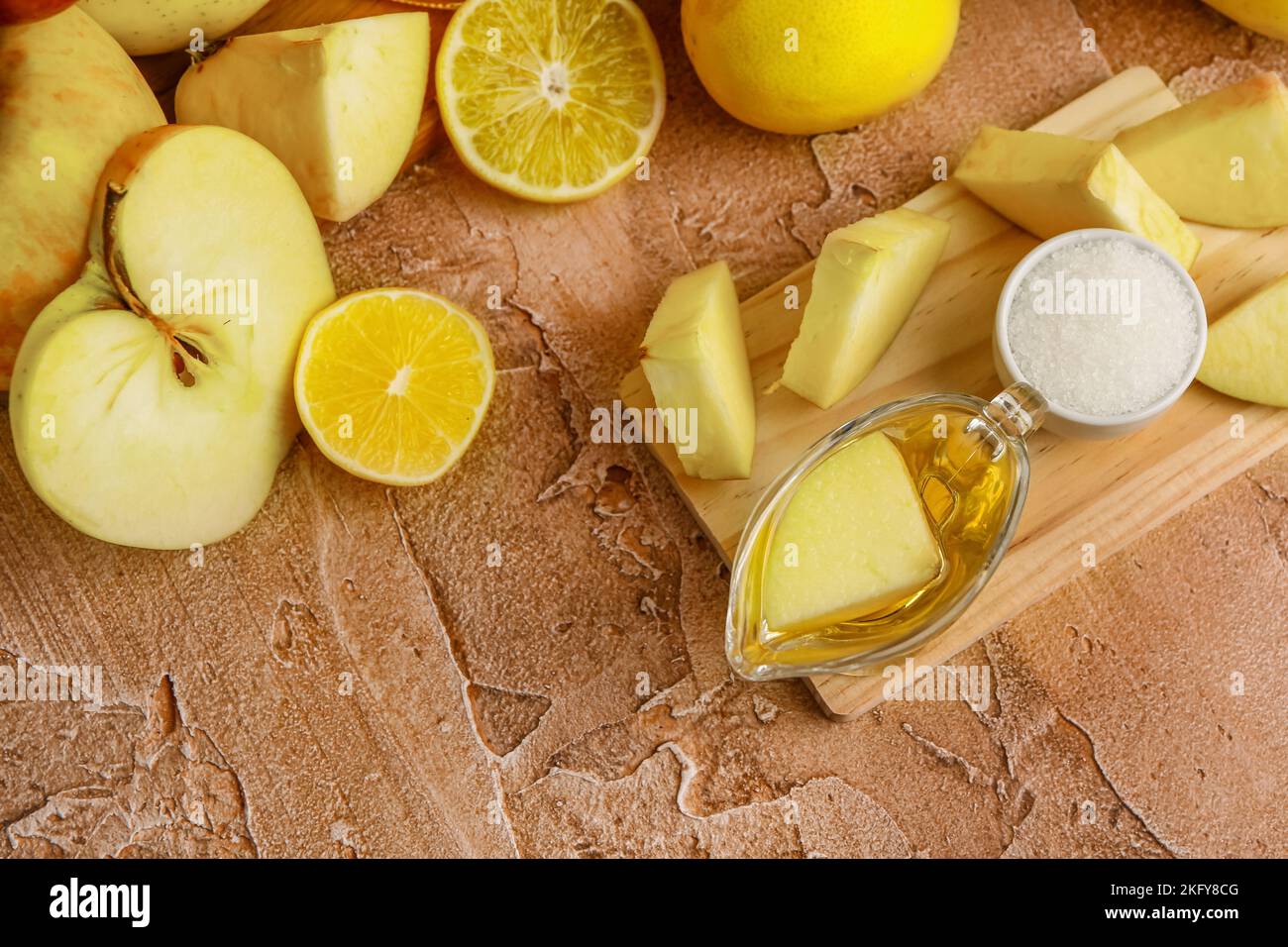 Wooden board with gravy boat of apple cider vinegar, sugar and fruits ...