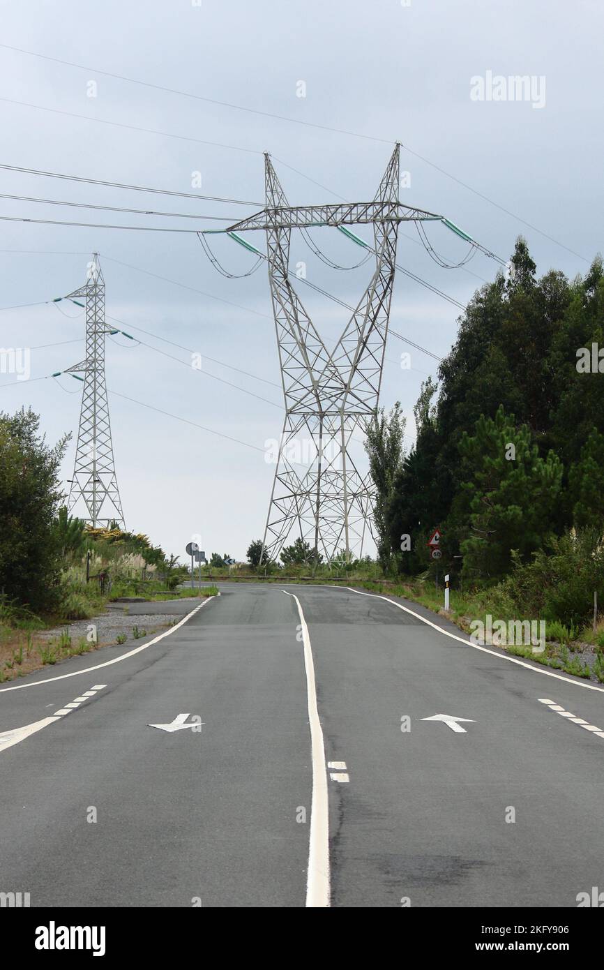 Power lines over a two-way road surrounded by plants Stock Photo - Alamy