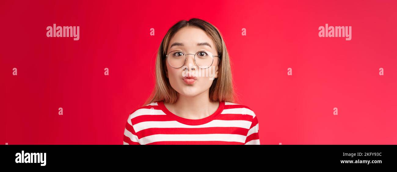 Cute pretty asian blond modern teenage girl folding lips anticipating ...